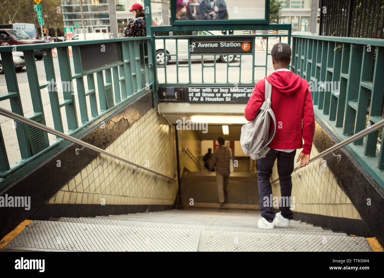 Rear view of student walking down steps in subway Stock Photo - Alamy