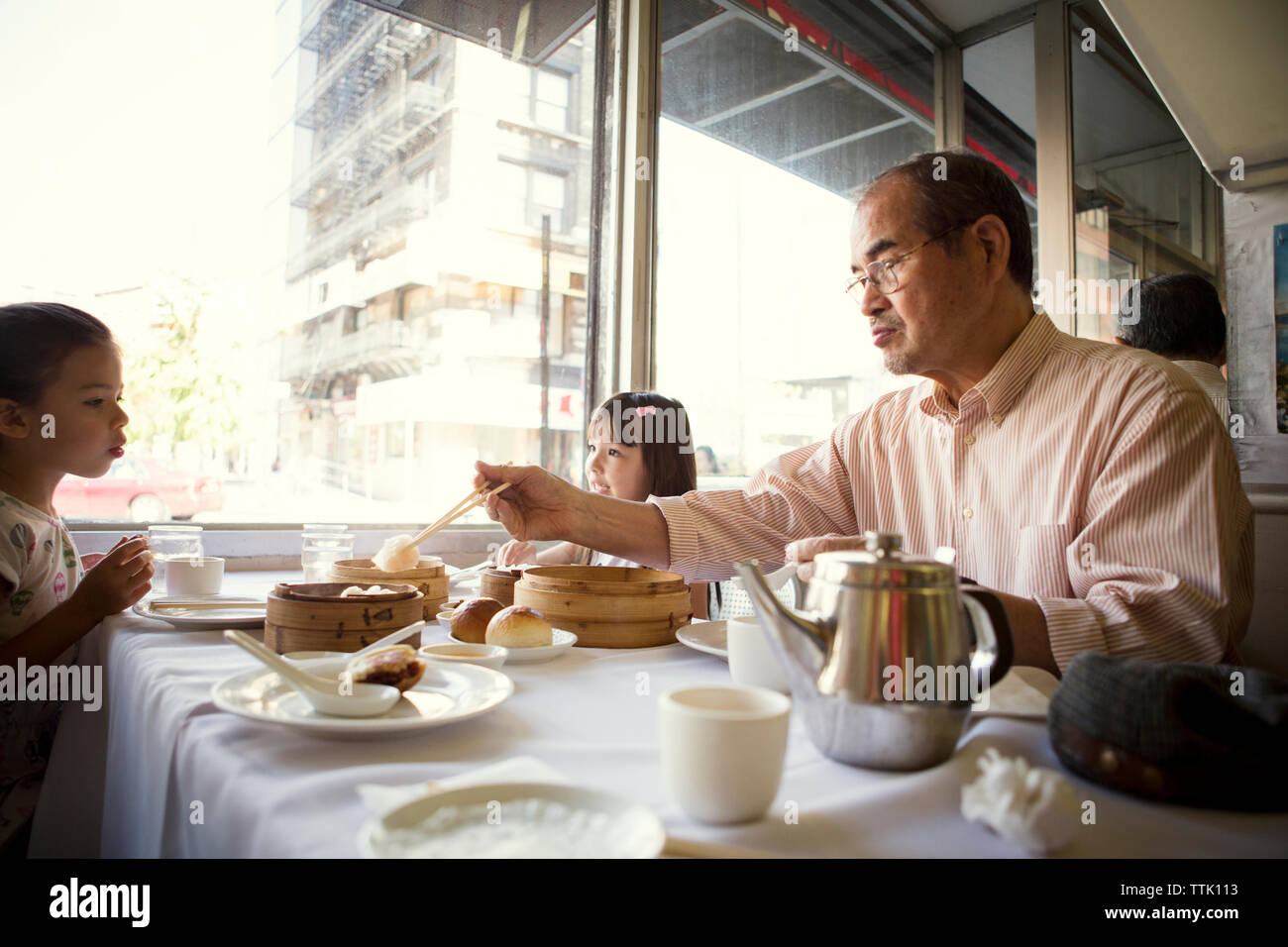 Family having food while sitting in restaurant Stock Photo - Alamy