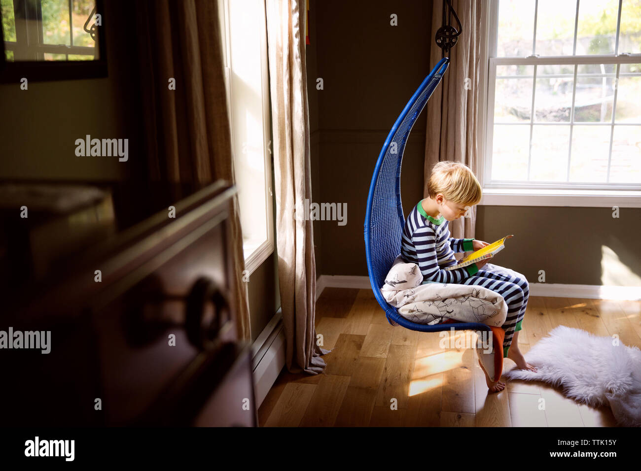 Boy sitting on floor reading book hi-res stock photography and images ...