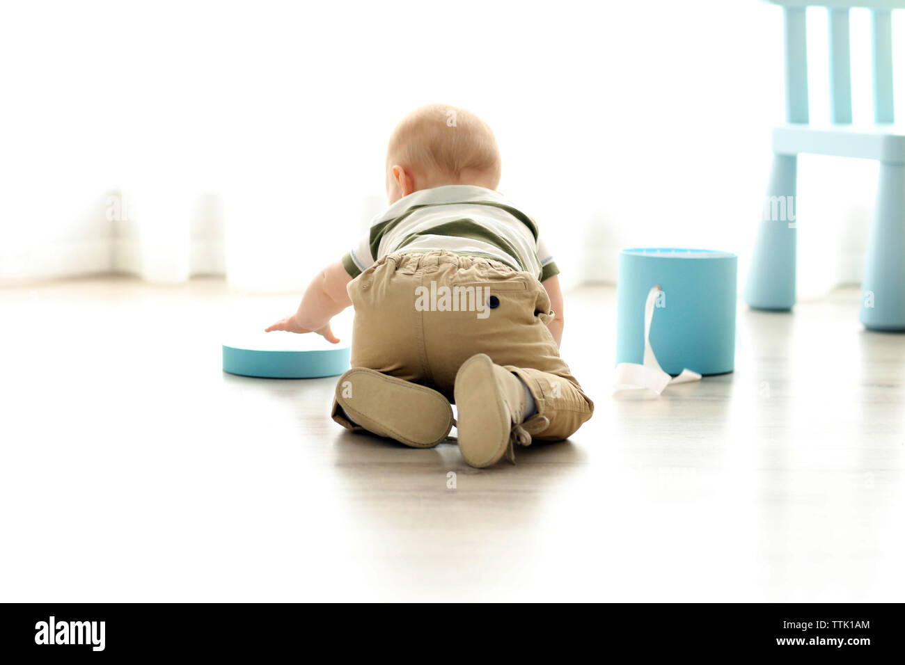 Adorable crawling baby on a wooden floor Stock Photo - Alamy