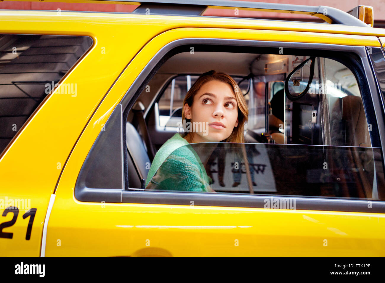 Woman looking through window while sitting in taxi at city Stock Photo ...