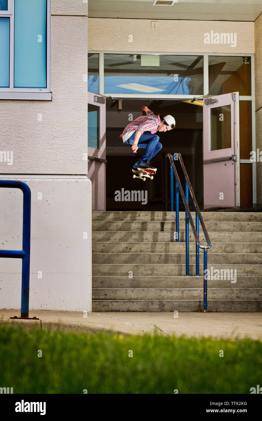 Side view of man performing stunt while skateboarding on steps Stock ...