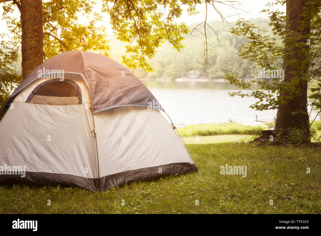 Tent on field against lake Stock Photo - Alamy