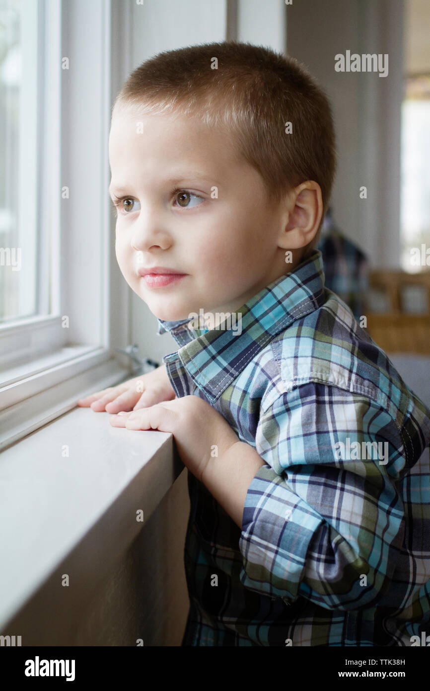 Childhood looking through window smiling innocence hi-res stock ...