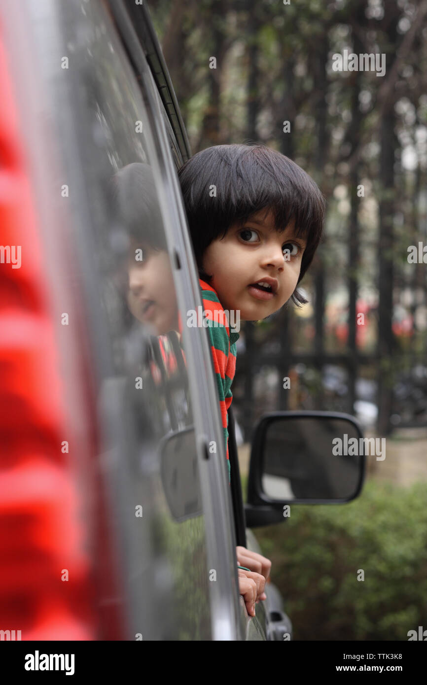 Indian girl leaning out of window of a car Stock Photo - Alamy