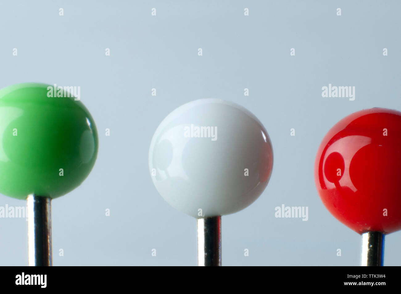 macrophotography of sphere shaped glass heads of pins in green, white ...