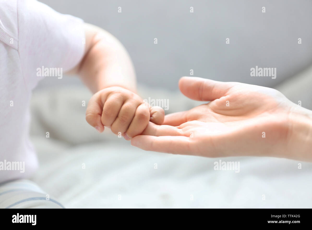 Woman holding small baby hand Stock Photo - Alamy