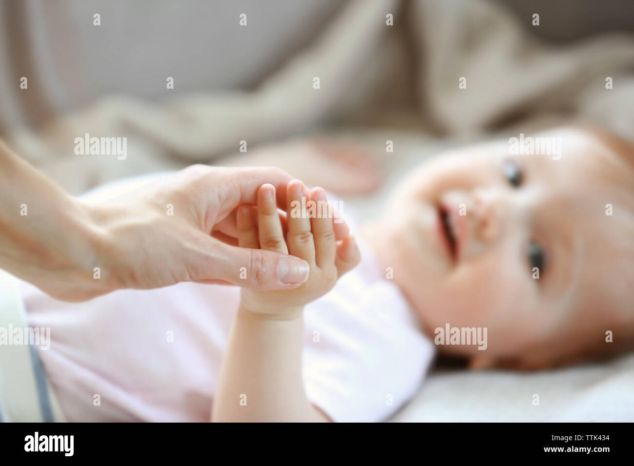 Woman holding small baby hand Stock Photo - Alamy
