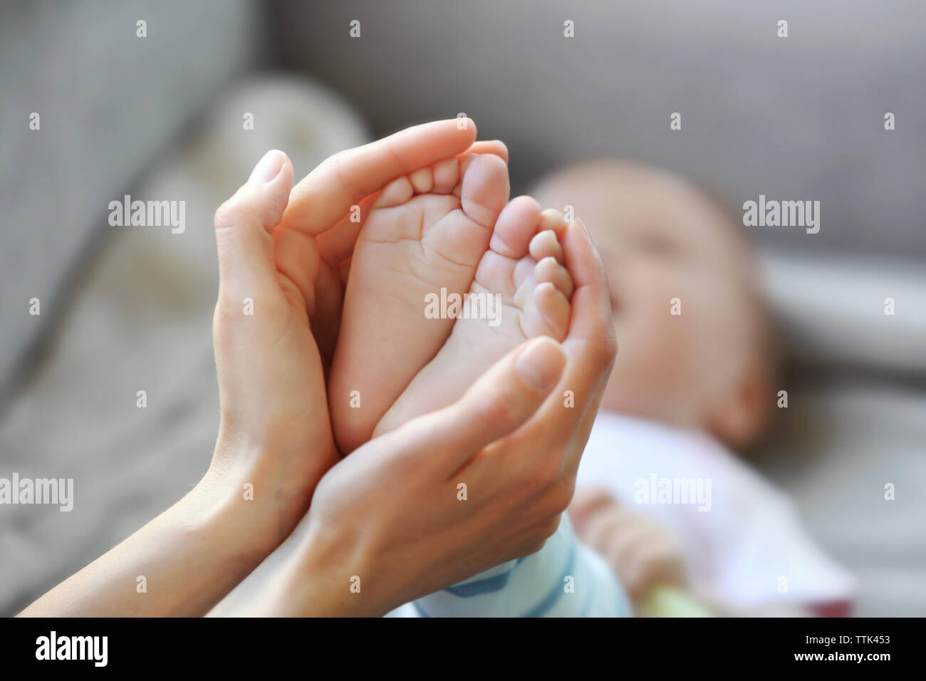 Woman holding small baby feet Stock Photo - Alamy