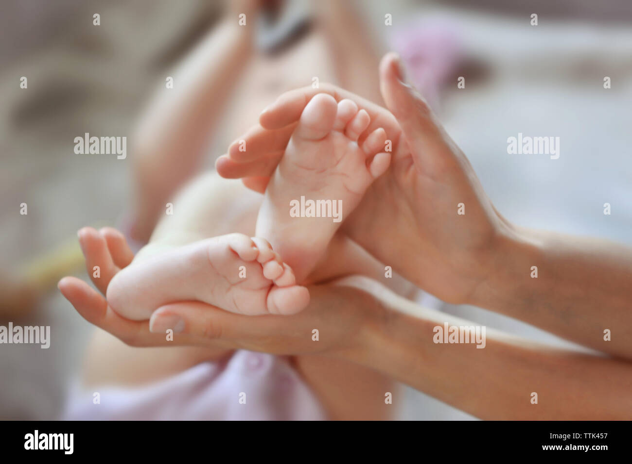 Woman holding small baby feet Stock Photo - Alamy