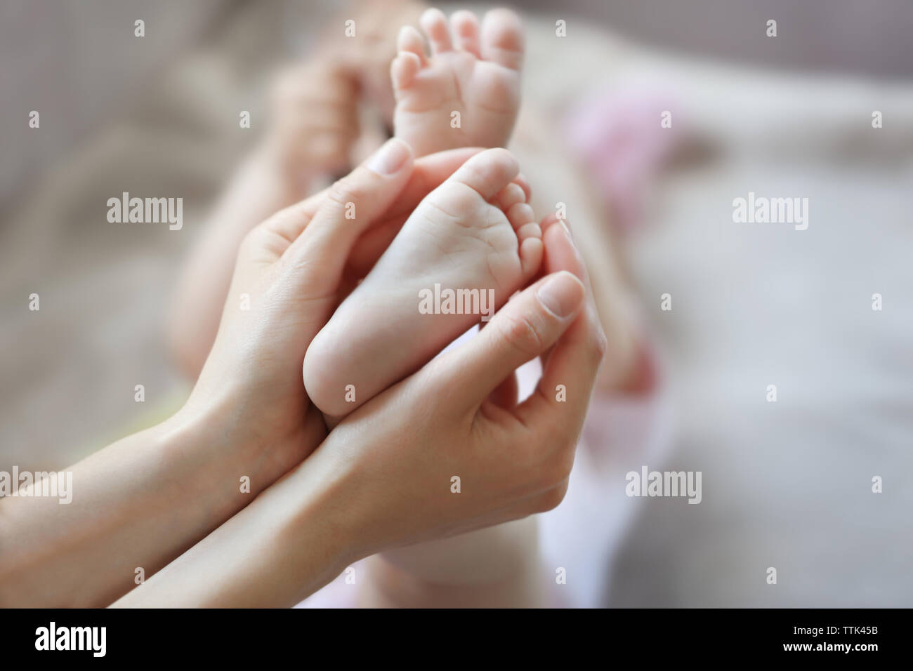 Woman holding small baby feet Stock Photo - Alamy