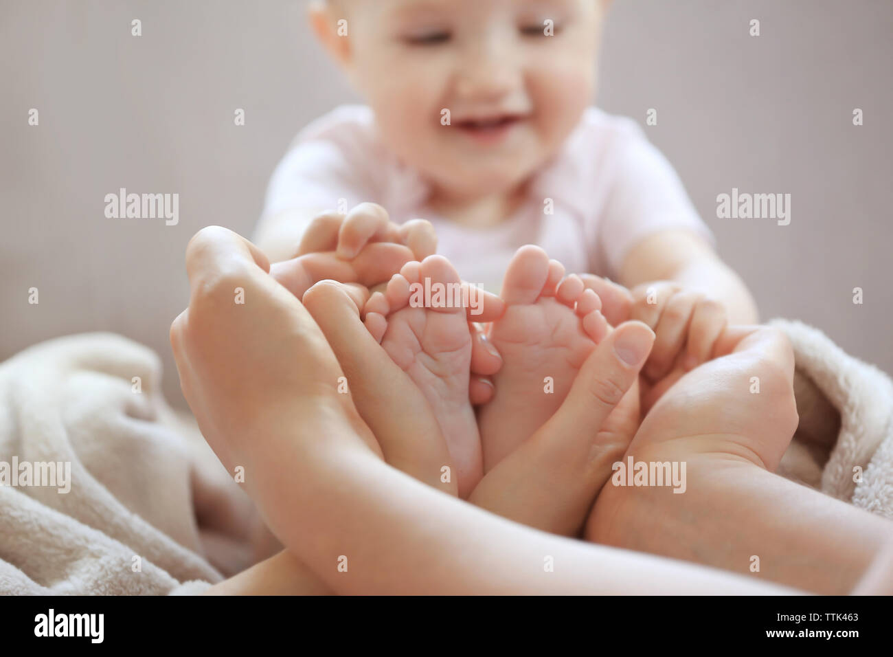Woman holding small baby feet Stock Photo - Alamy