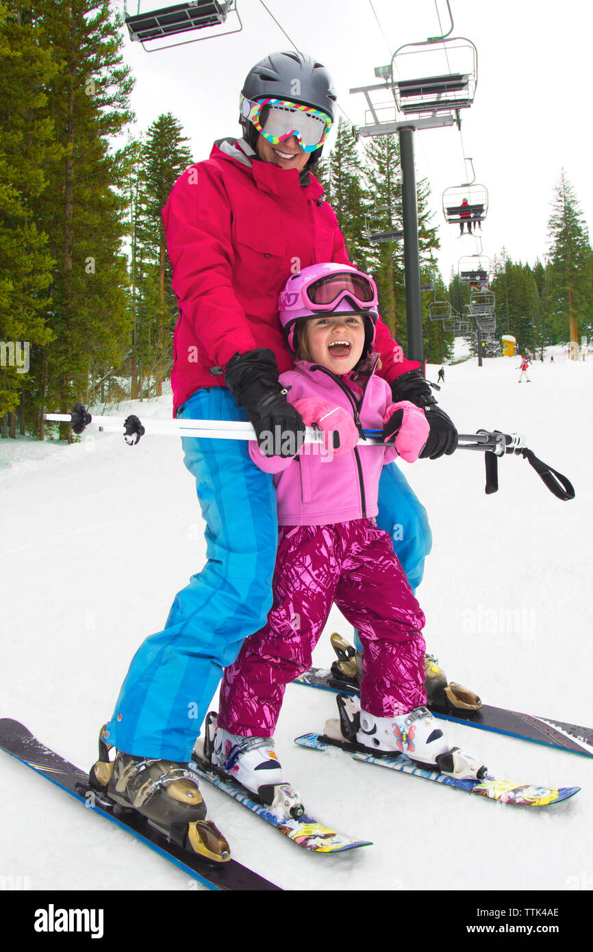 Happy mother and girl skiing on snow covered field Stock Photo - Alamy