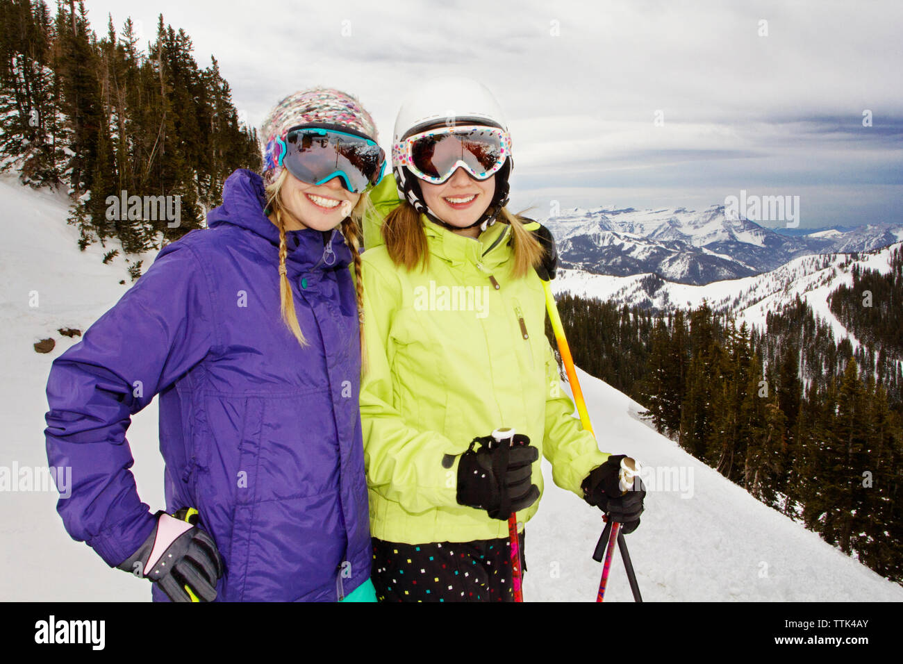 Female friends skiing on snow covered field against mountains Stock ...