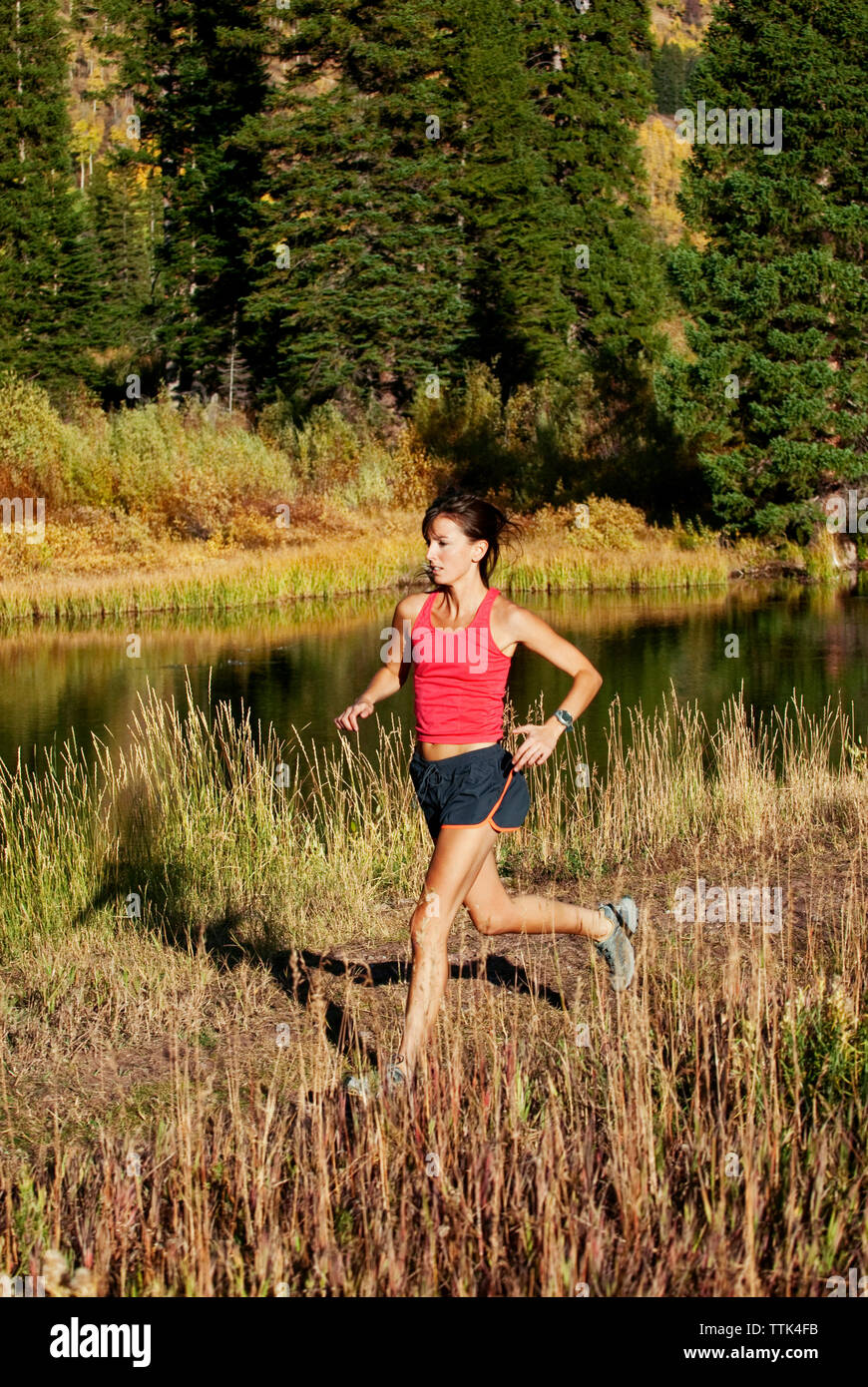 Woman running on lakeshore Stock Photo - Alamy