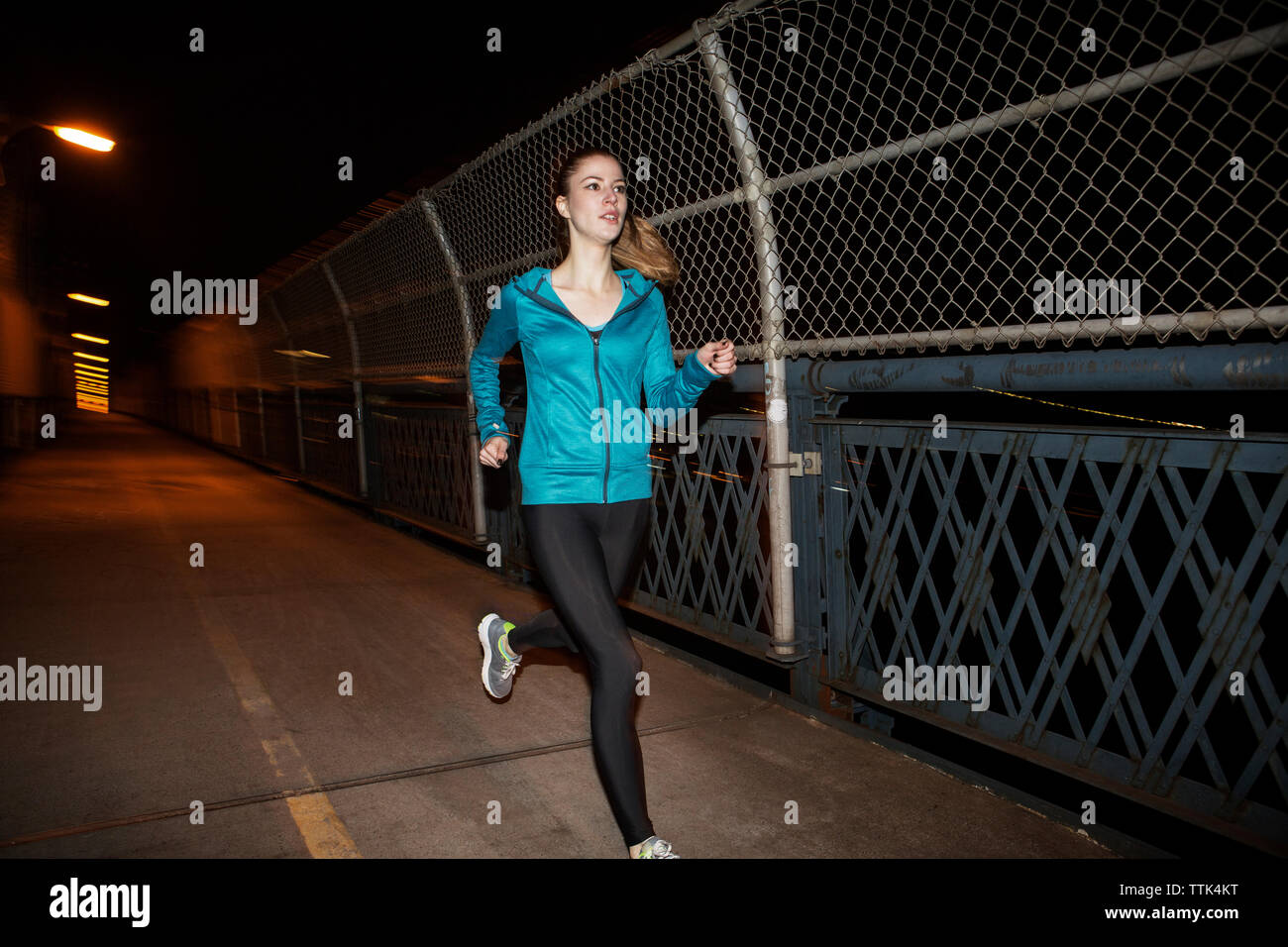 Young woman jogging on bridge at night Stock Photo - Alamy