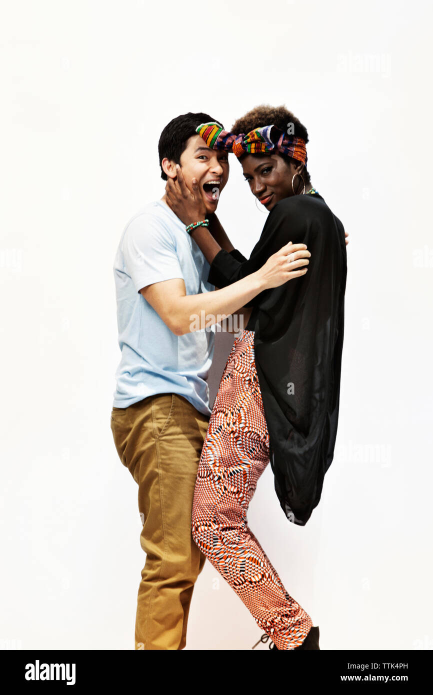 Surprised man with smiling teenager standing against white background ...