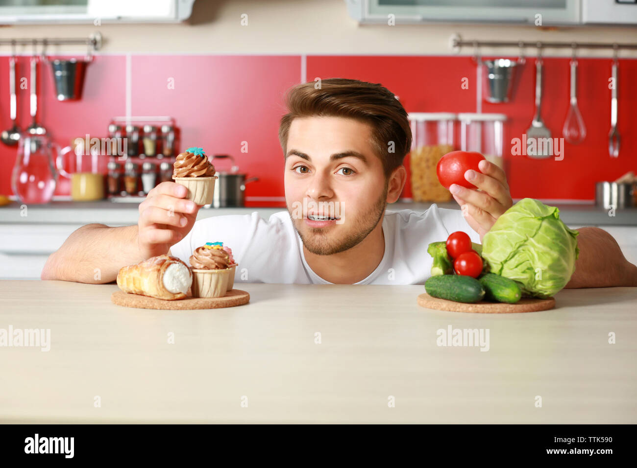 Man with healthy and unhealthy food in kitchen Stock Photo - Alamy