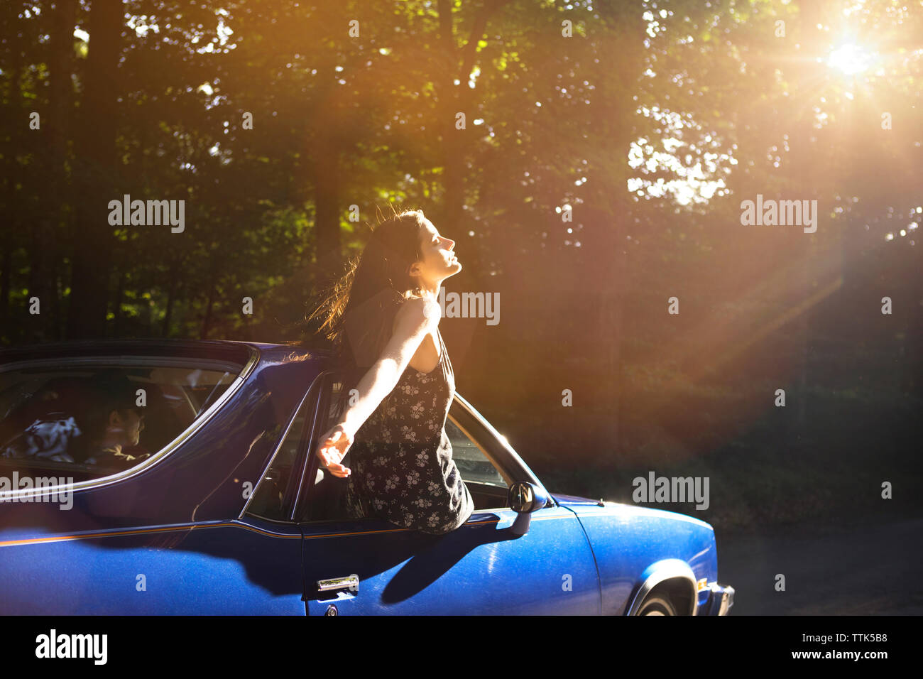 Woman with arm outstretched leaning out of pick-up truck window in ...