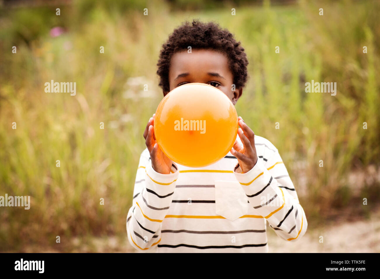 Boy blowing up balloon hi-res stock photography and images - Alamy