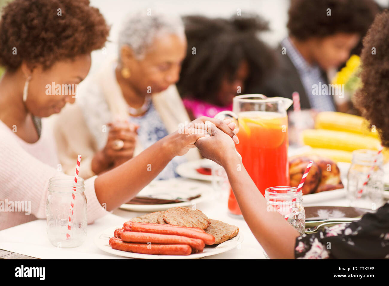 Family holding hands while praying at breakfast table Stock Photo - Alamy