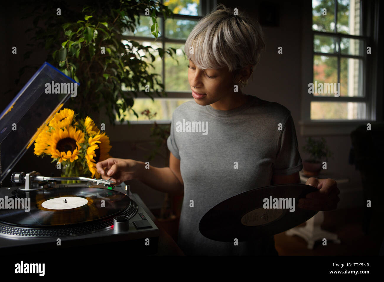 Woman placing vinyl record on turntable at home Stock Photo - Alamy