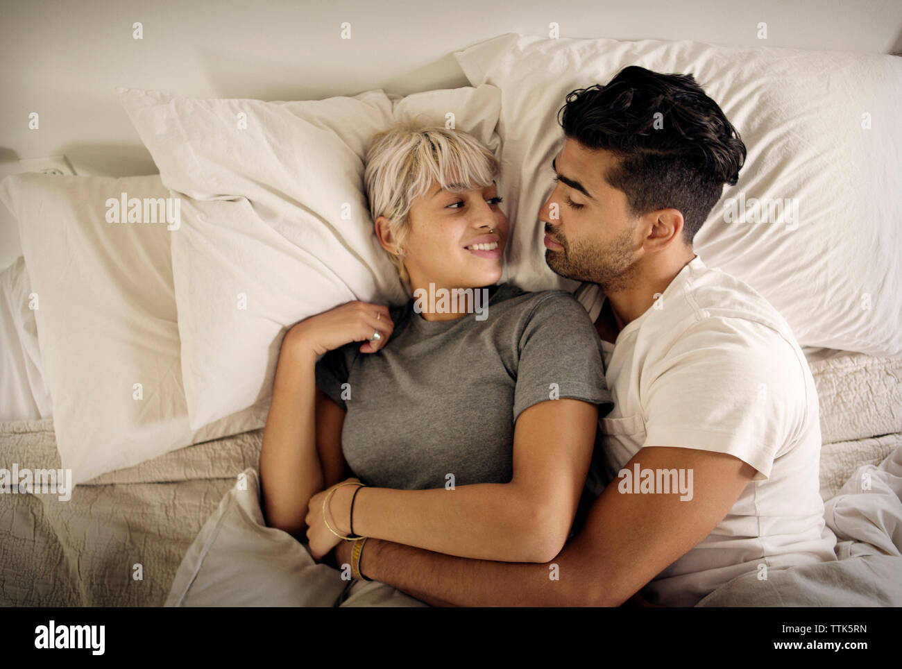 Overhead view of young couple relaxing on bed at home Stock Photo - Alamy