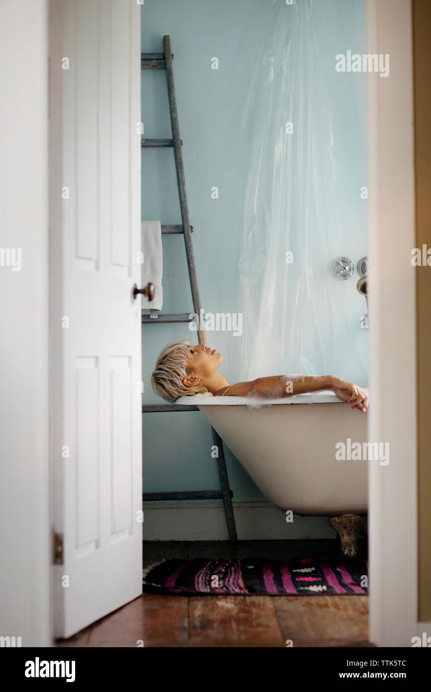 Side view of woman relaxing in bathtub at home Stock Photo - Alamy