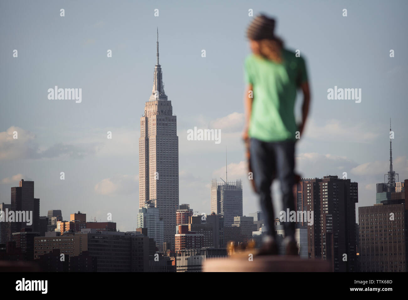 Man standing on column with empire state building in background Stock ...