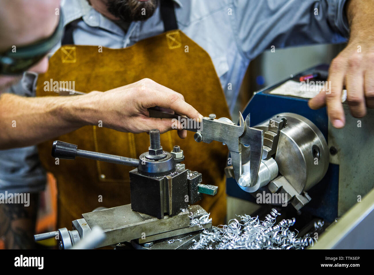 Cropped image of mechanics working on machinery in auto repair shop ...
