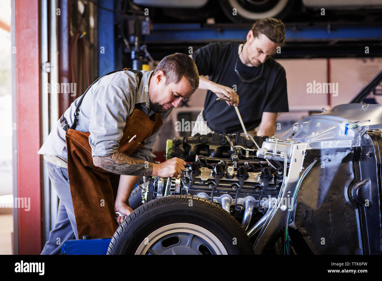 Mechanics repairing car engine in auto repair shop Stock Photo - Alamy