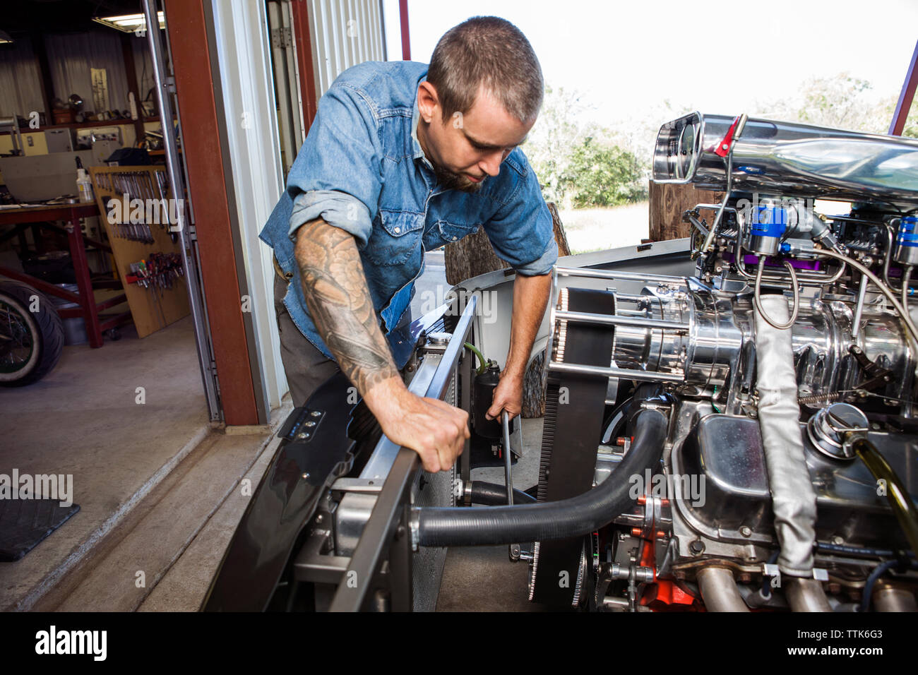 Mechanic repairing engine in auto repair shop Stock Photo - Alamy