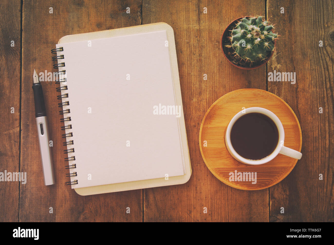 Open notebook with empty pages and other office supplies over wooden ...