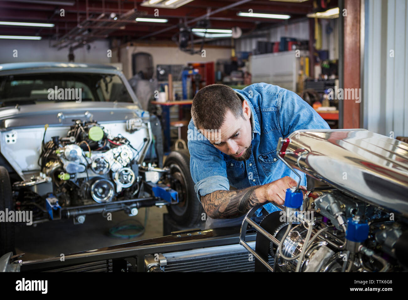 Mechanic repairing car engine in auto repair shop Stock Photo - Alamy