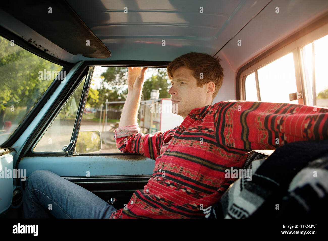 Side view of man sitting in pick-up truck Stock Photo - Alamy