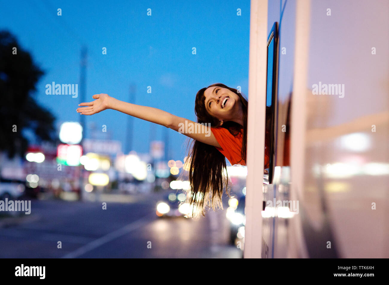 Cheerful woman waving while leaning out of camper van Stock Photo - Alamy