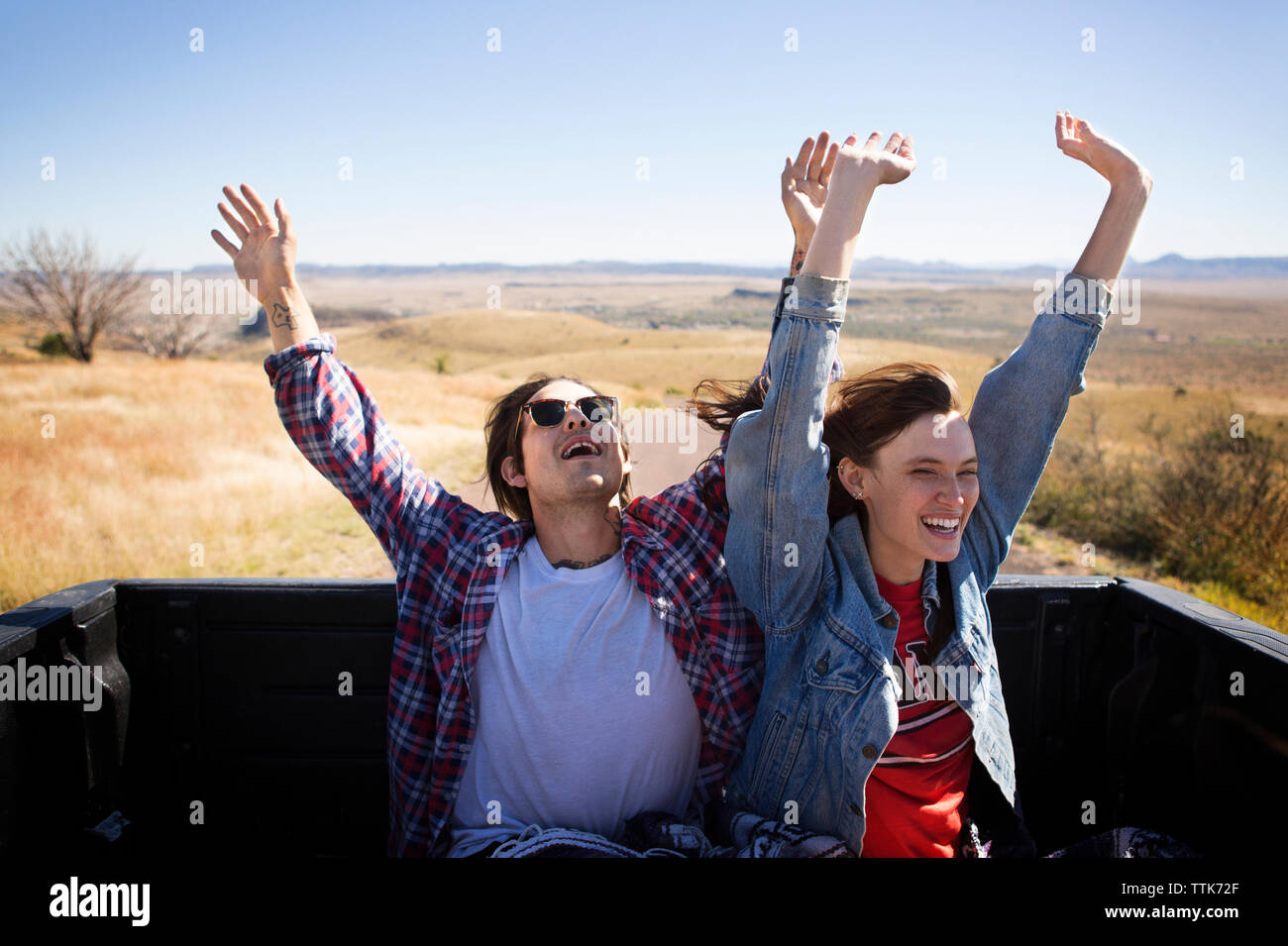 Happy couple with arms raised traveling in pick-up truck Stock Photo ...