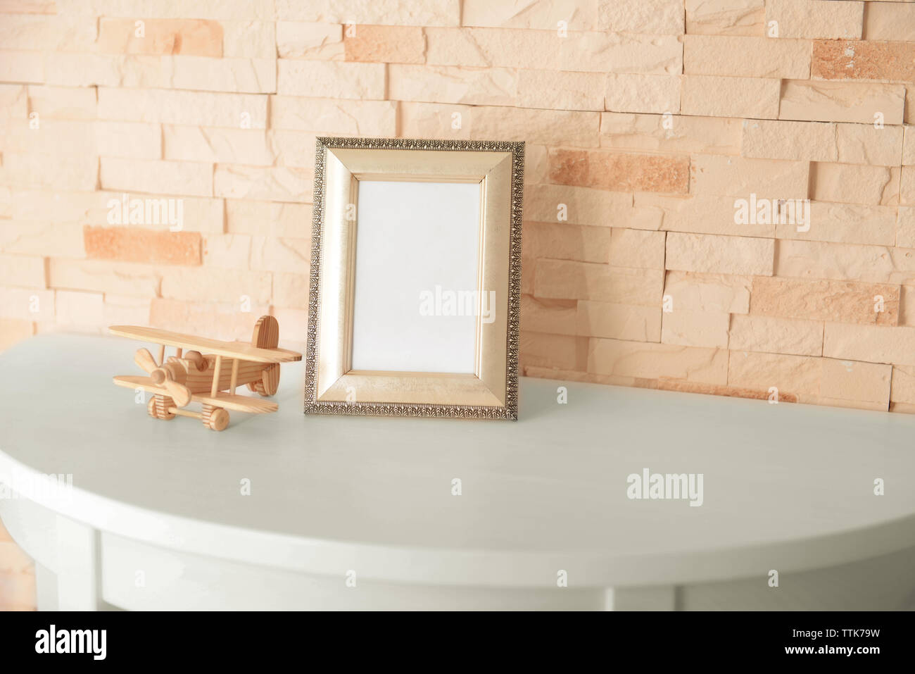 Photo frame and small wooden airplane on brick wall background Stock ...