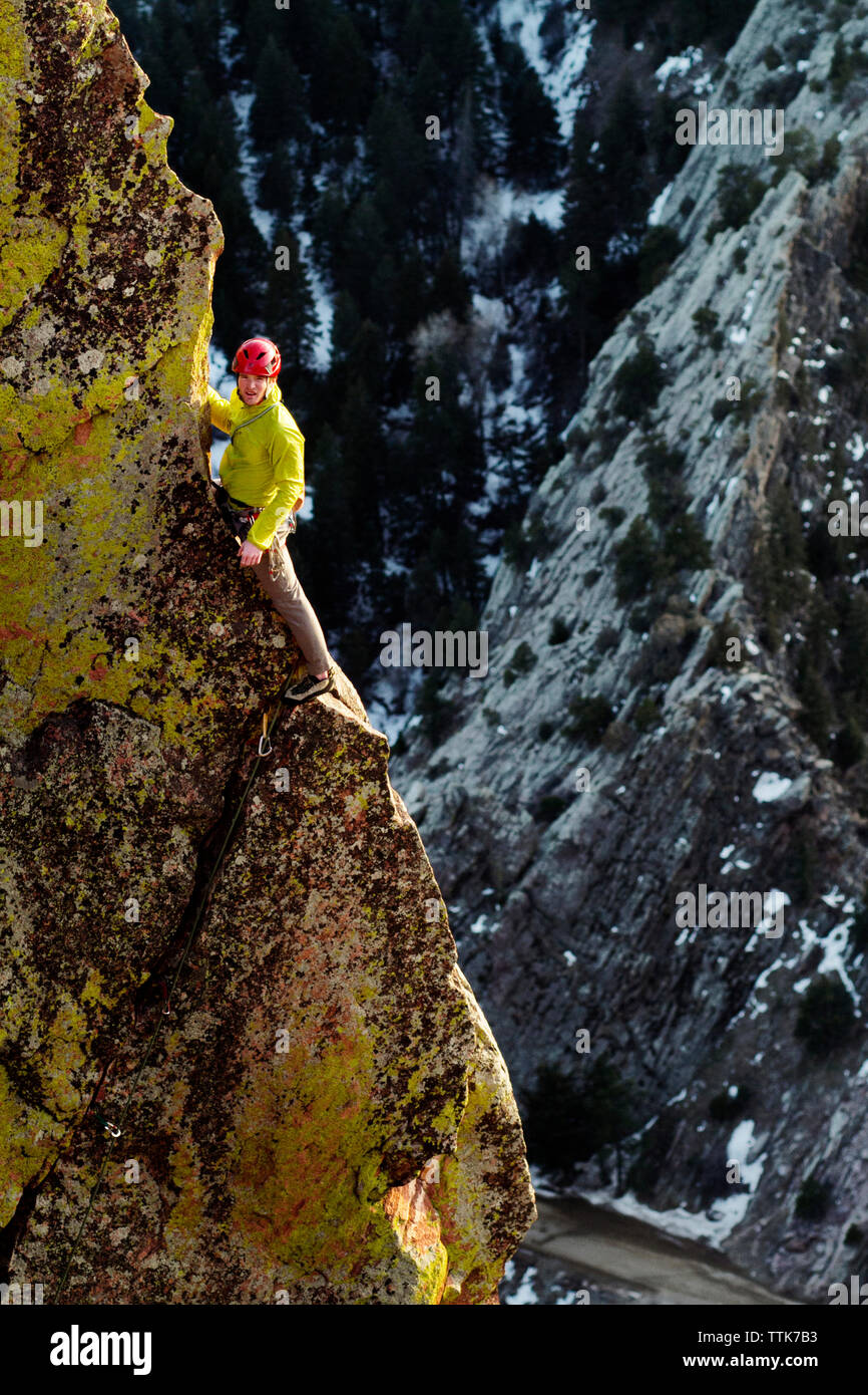 Male climber standing on rock mountain Stock Photo - Alamy