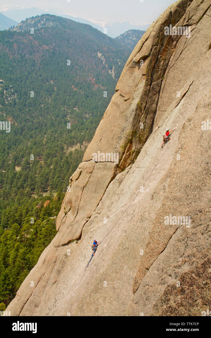 Distant view of female hikers climbing mountain Stock Photo - Alamy
