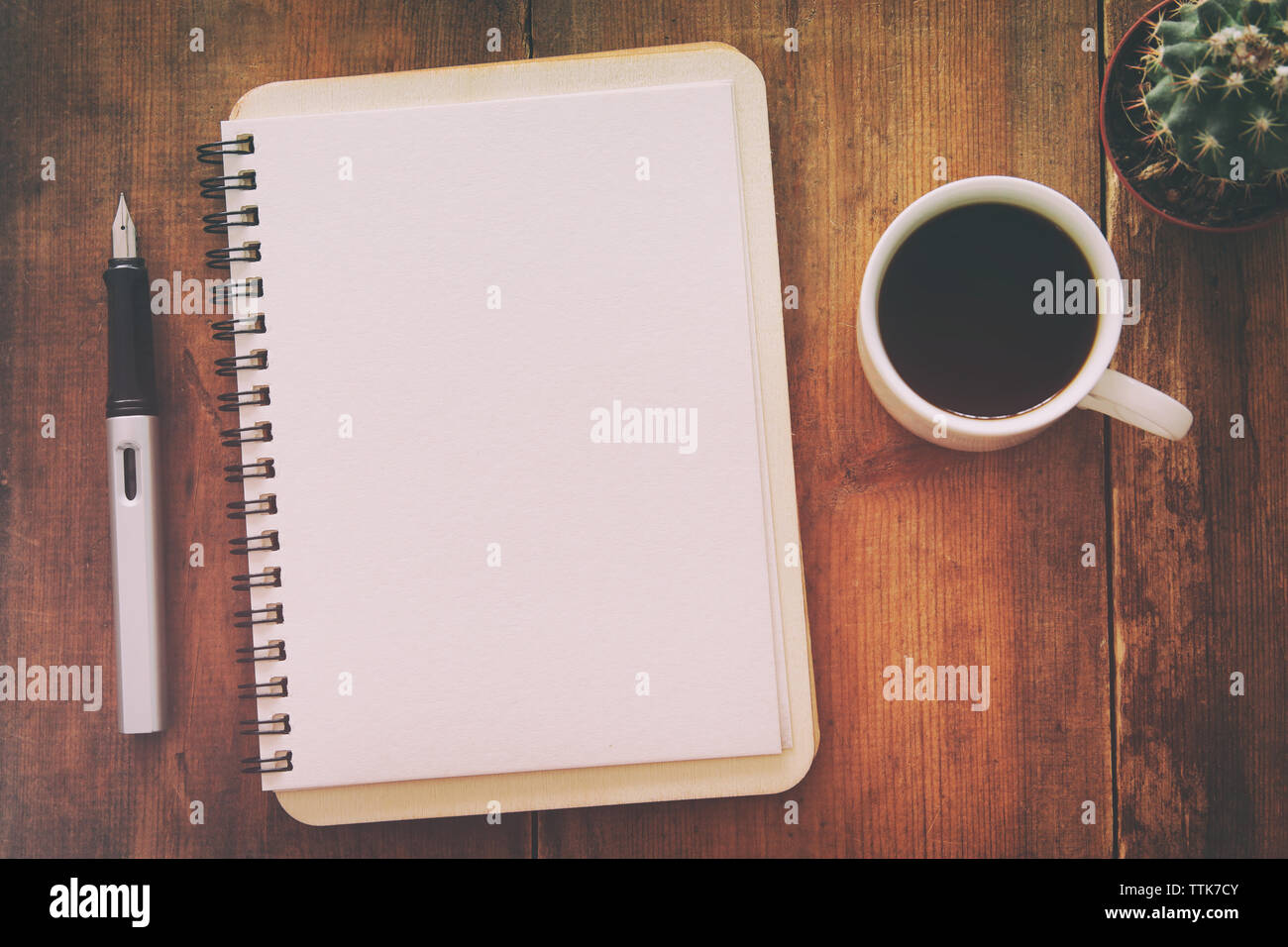 Open notebook with empty pages and other office supplies over wooden ...