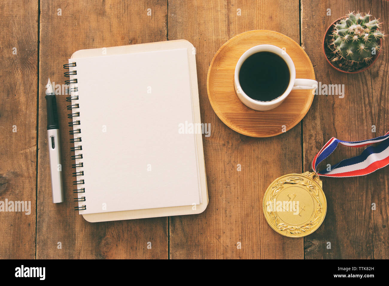 Open notebook with empty pages and other office supplies over wooden ...