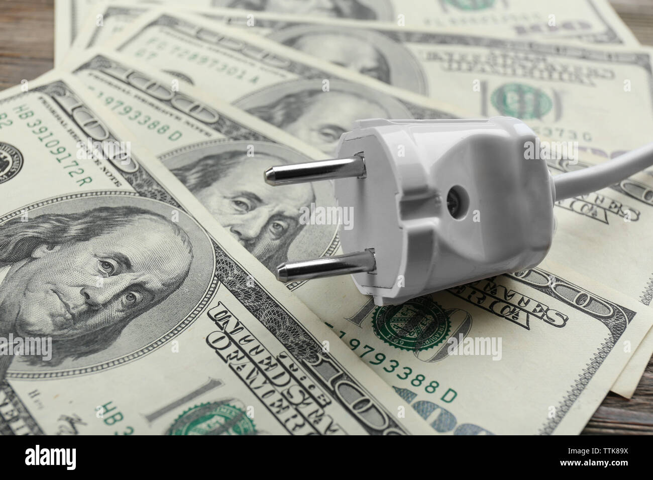 Plug on dollars background Stock Photo - Alamy