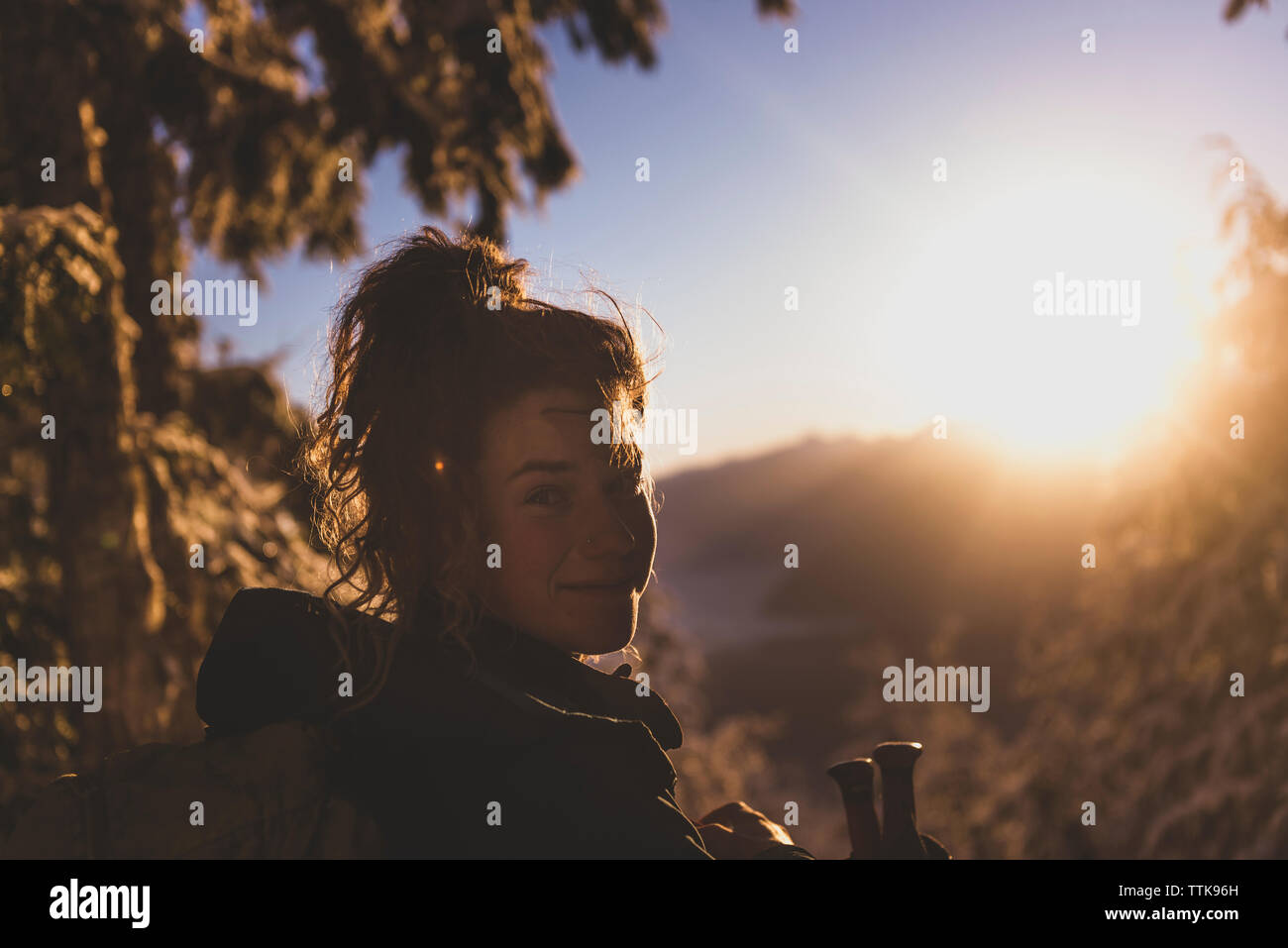 Woman looking back at camera at sunset Stock Photo - Alamy