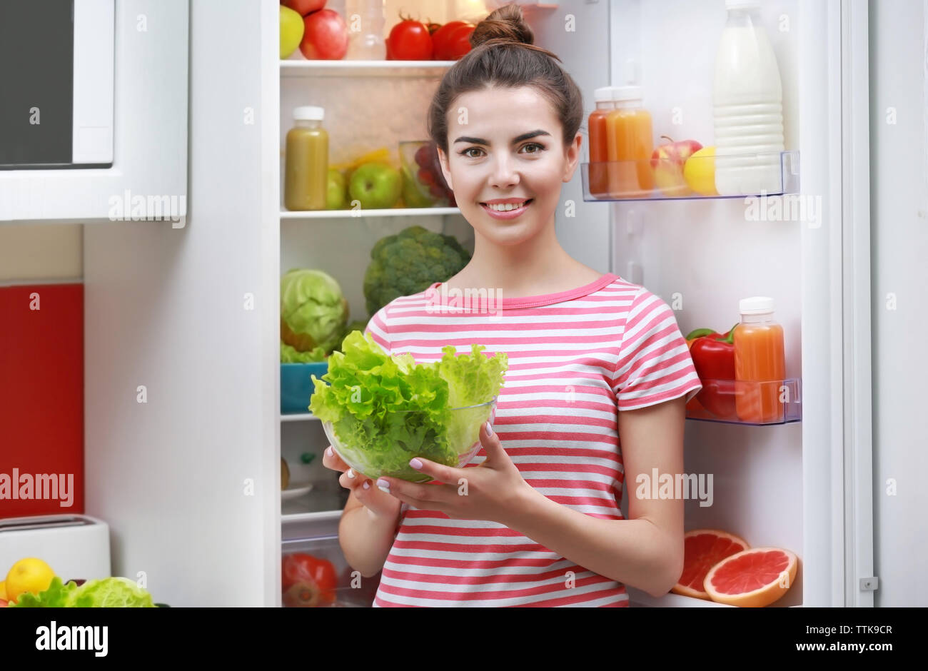 Young woman standing beside fridge, closeup Stock Photo - Alamy