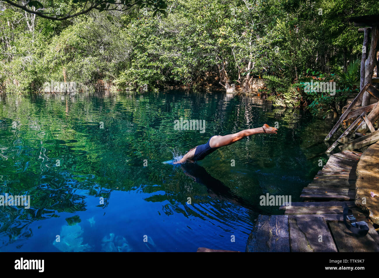 Side view of woman diving into lake Stock Photo - Alamy