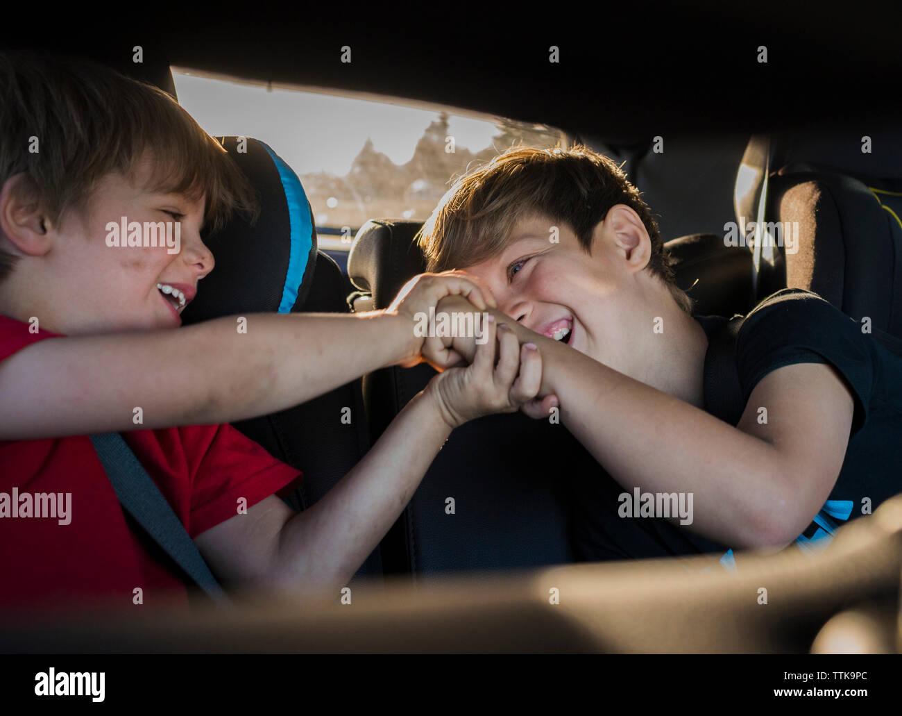 Cheerful brothers playing while travelling in car Stock Photo - Alamy