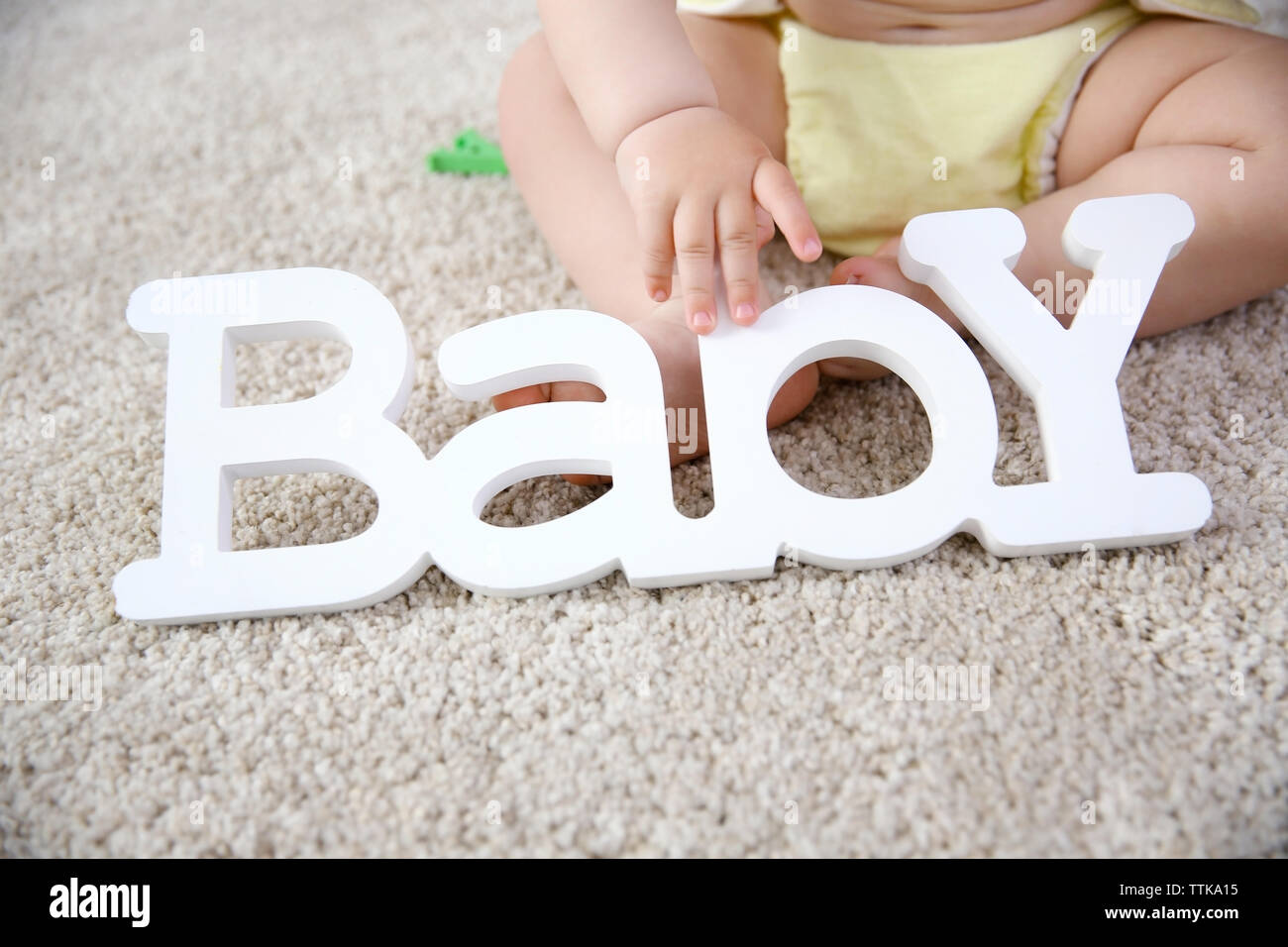 Baby and decorative word on the floor Stock Photo - Alamy