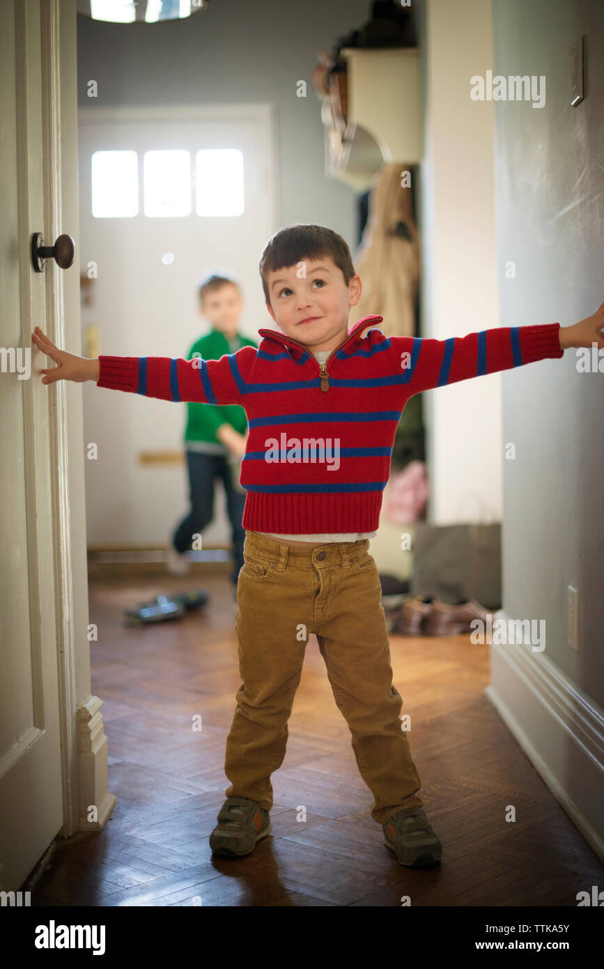 Boy standing with arms outstretched on floor at home Stock Photo - Alamy