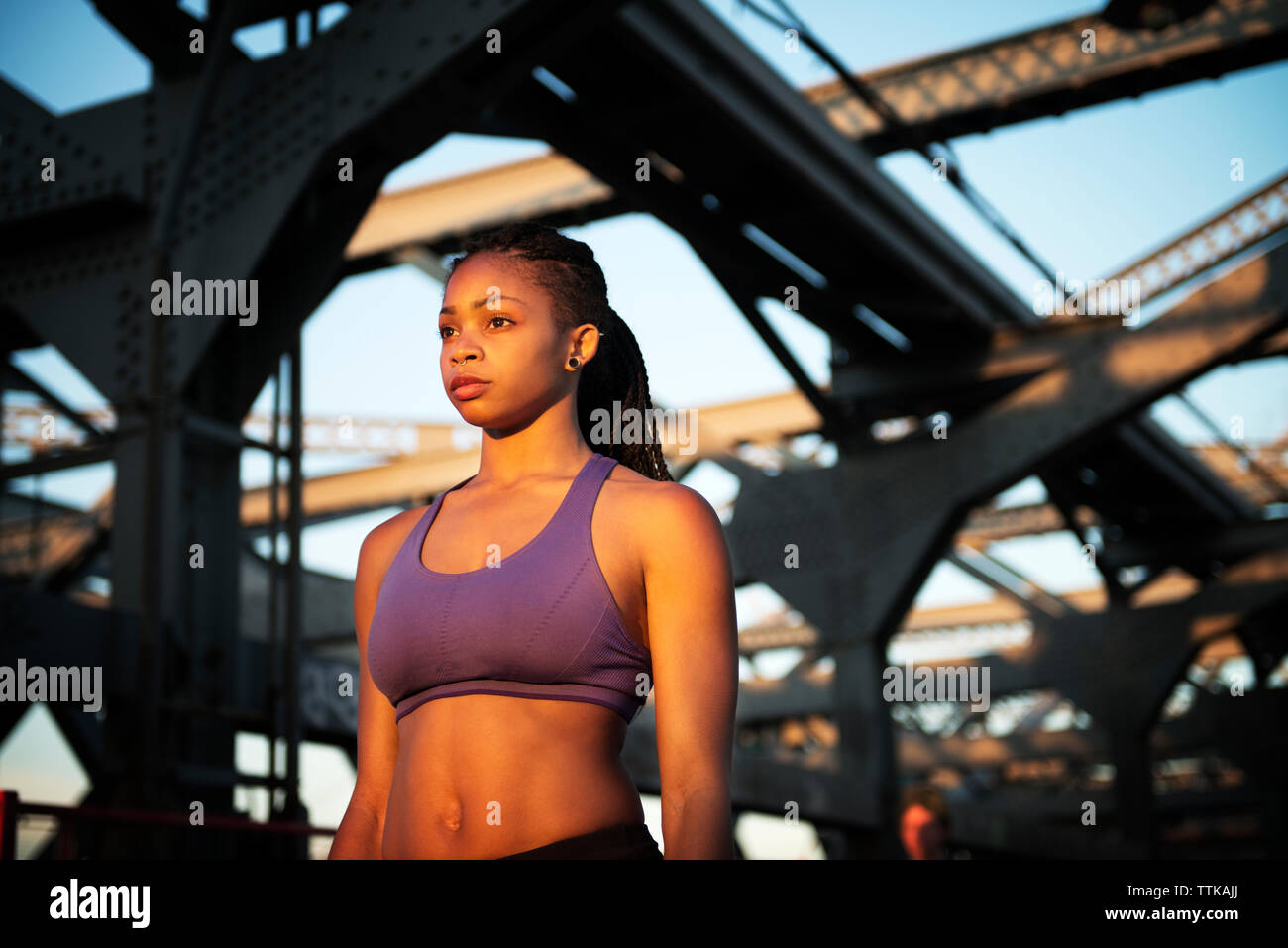 Front view of confident woman relaxing while standing on bridge Stock ...